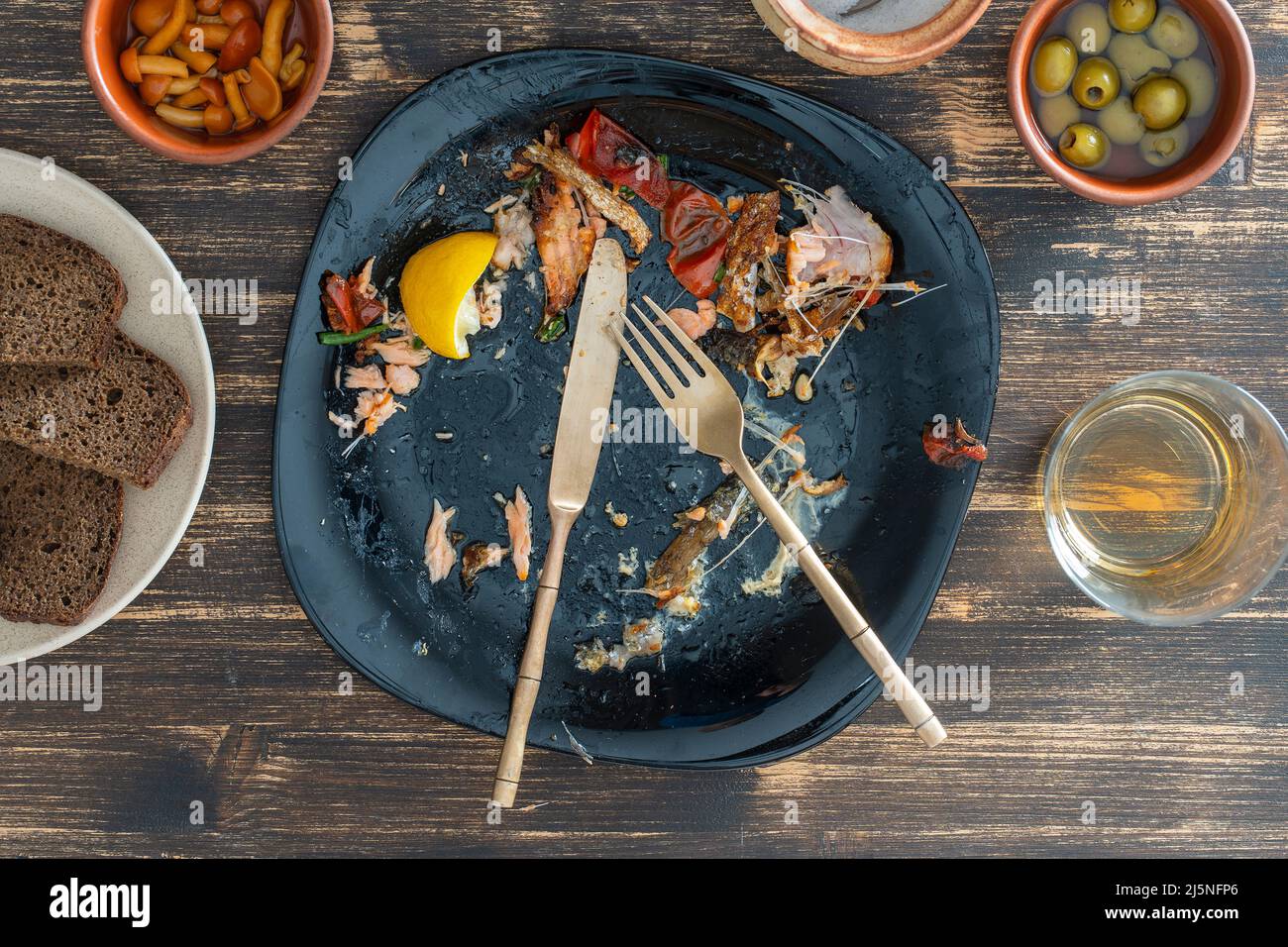 Top view of empty black plate, dirty after the meal is finished. Dirty ...