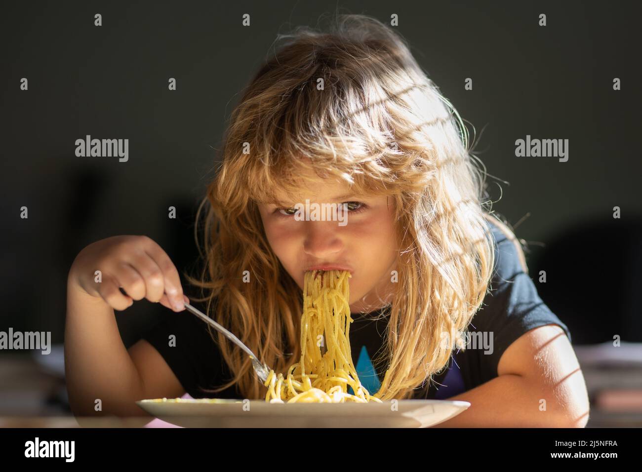 Child eating on blurred background. Hungry little boy eating. Home food ...