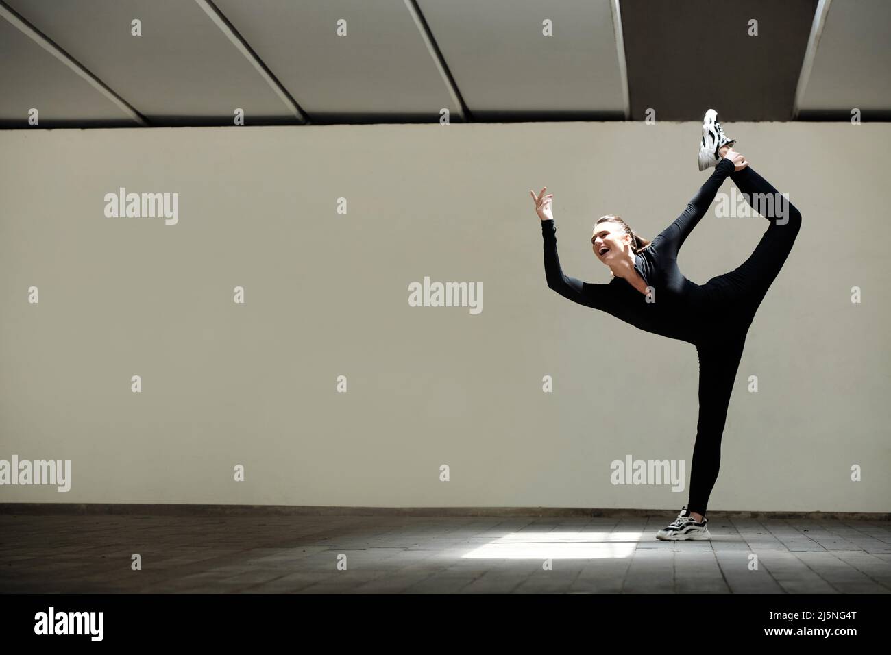 Excited flexible female dancer performing in underground parking or ...
