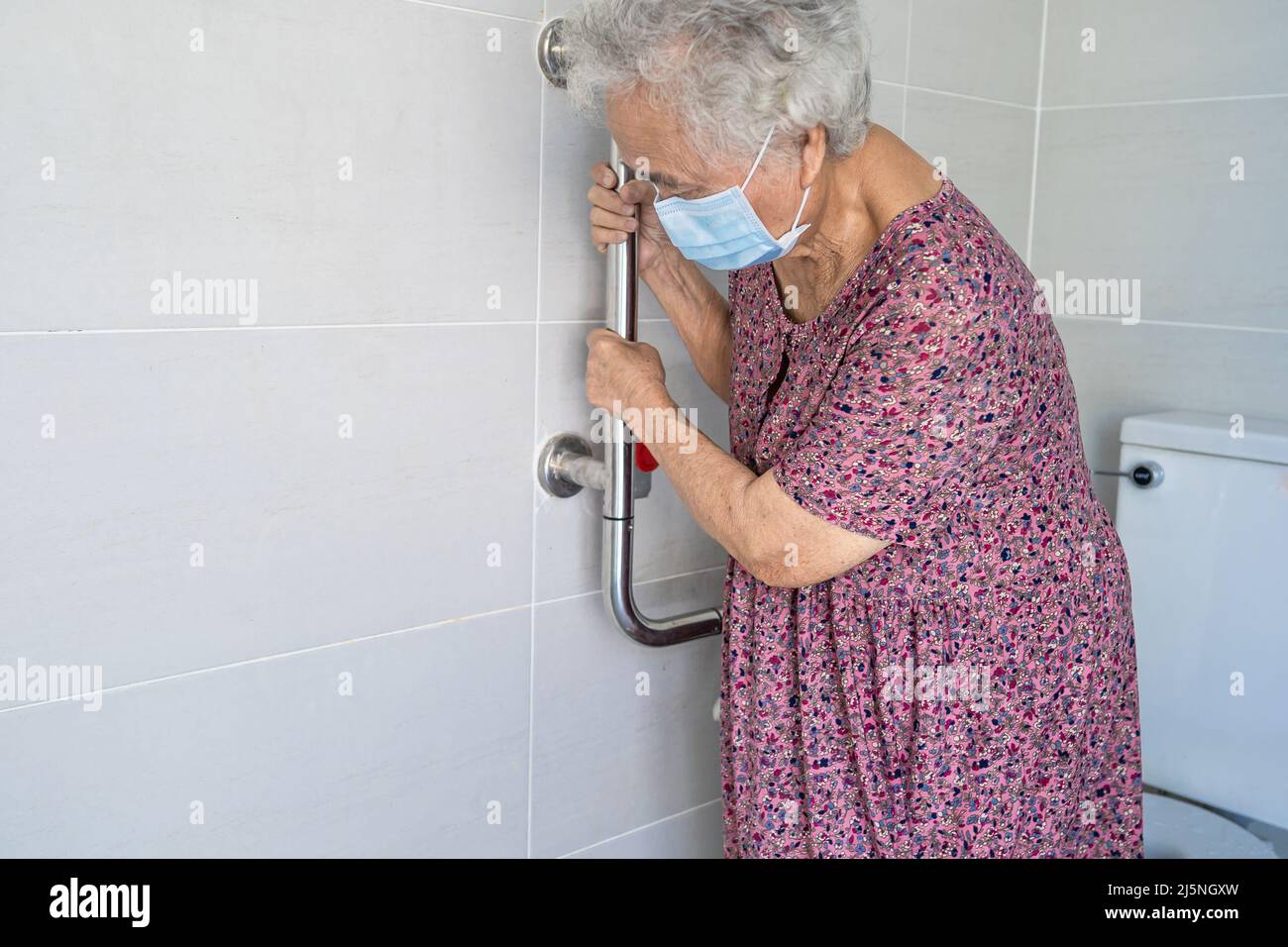 Asian senior or elderly old lady woman patient use toilet bathroom ...