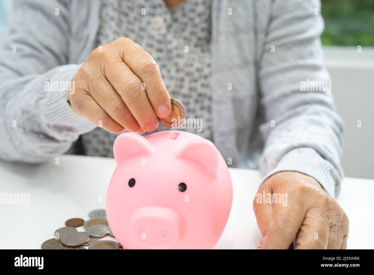 Asian senior or elderly old lady woman holding counting coin money in ...
