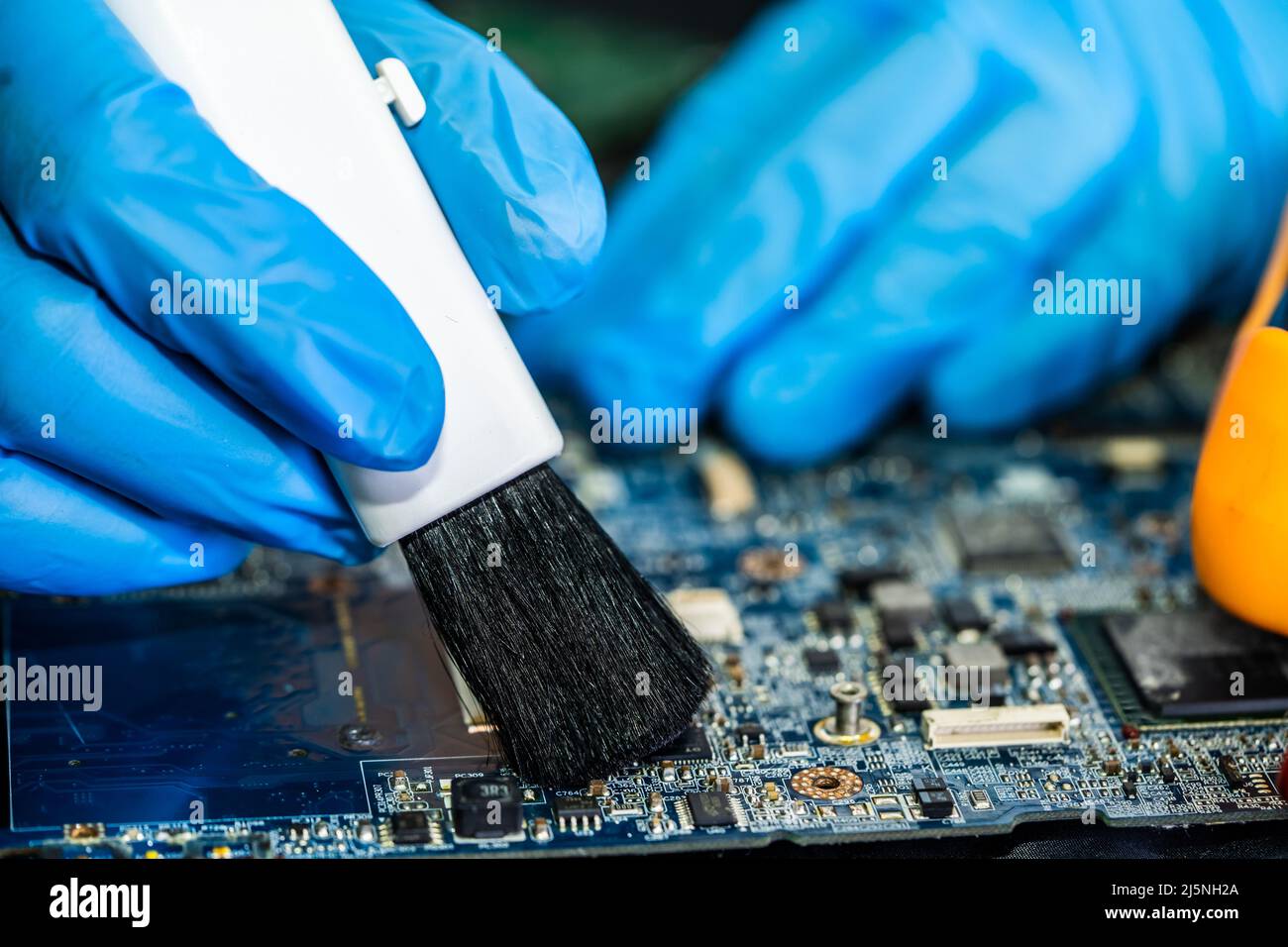 Technician use brush and air blower ball to clean dust in circuit board ...