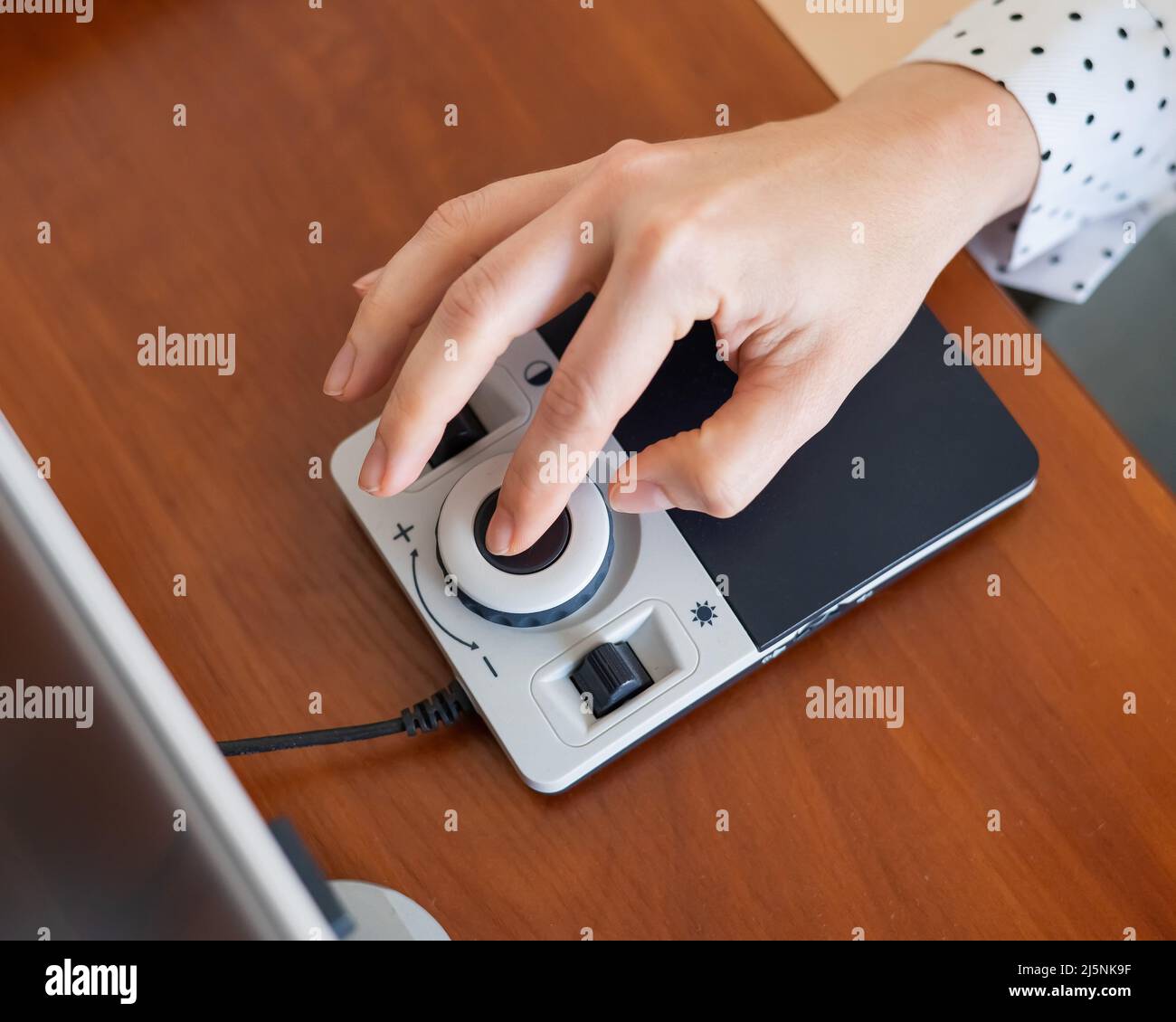 A woman uses a special magnification device for the visually impaired ...