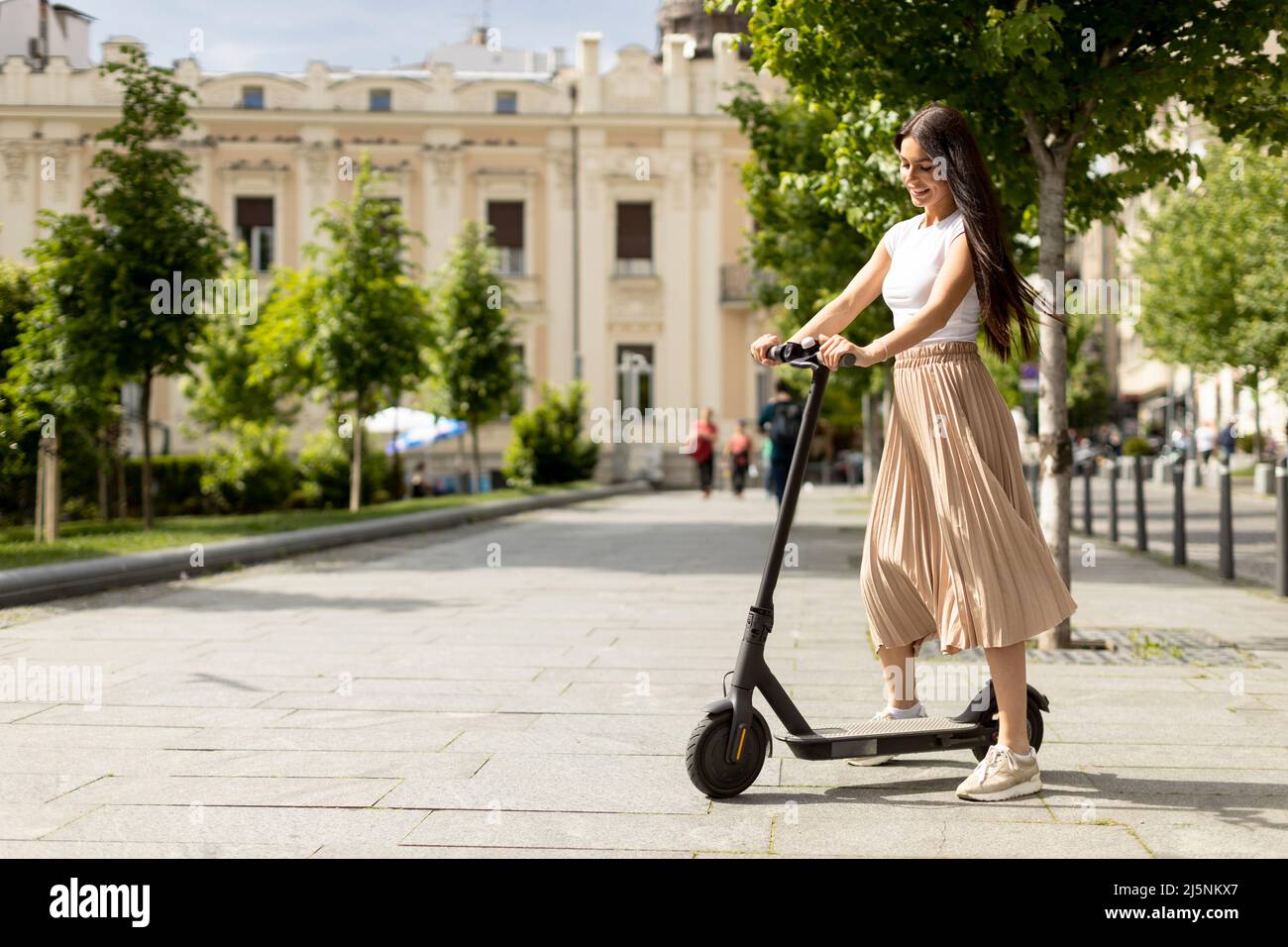 Pretty young woman riding an electric scooter on a street Stock Photo ...