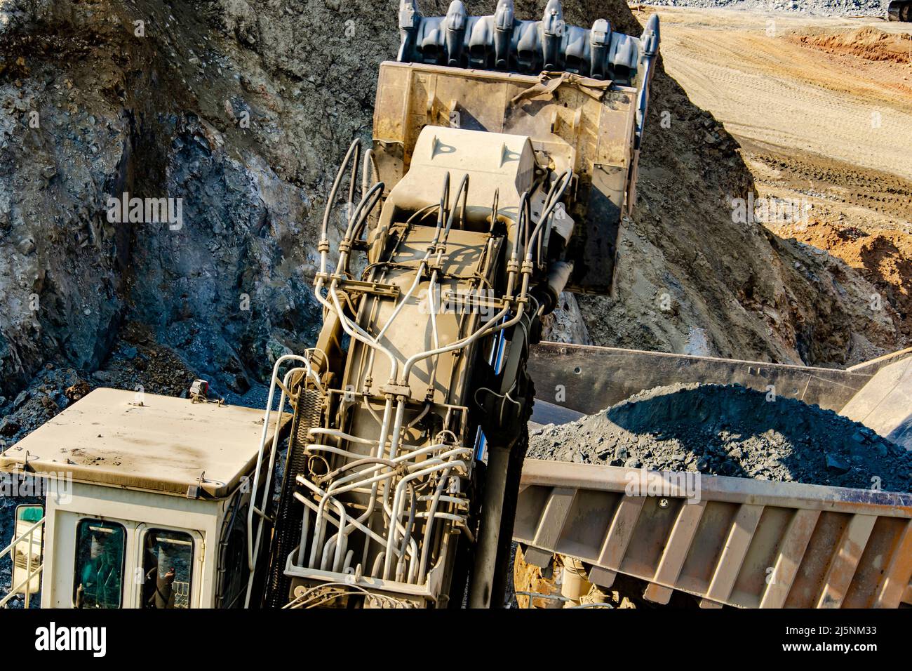 Excavator loading big dump truck in the open pit Stock Photo - Alamy