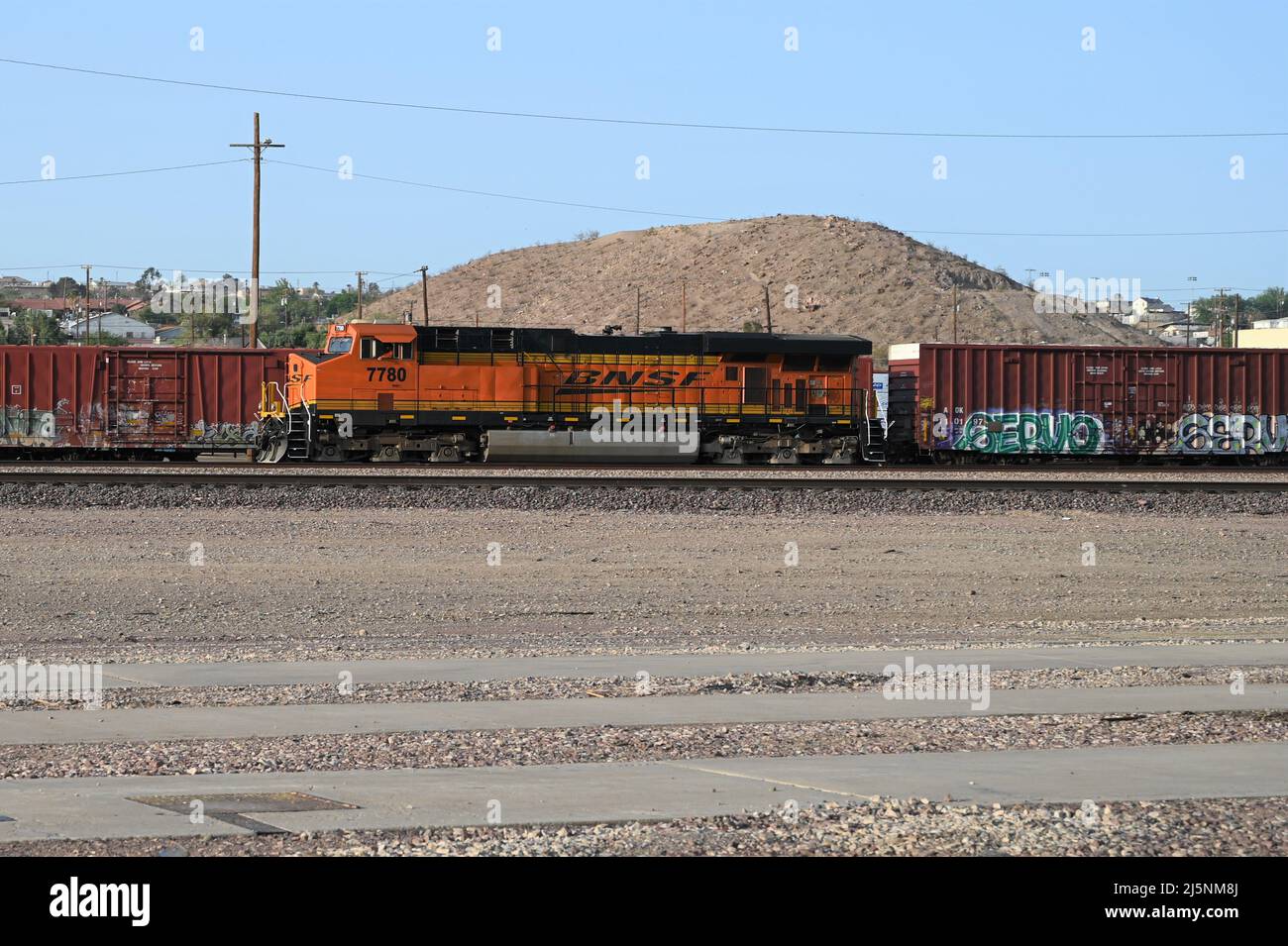 BNSF 7780 BNSF Railway GE ES44DC locomotive passing through Barstow station with a freight train ...