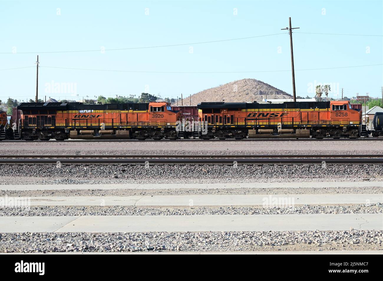 BNSF 7780 BNSF Railway GE ES44DC locomotive passing through Barstow station with a freight train ...