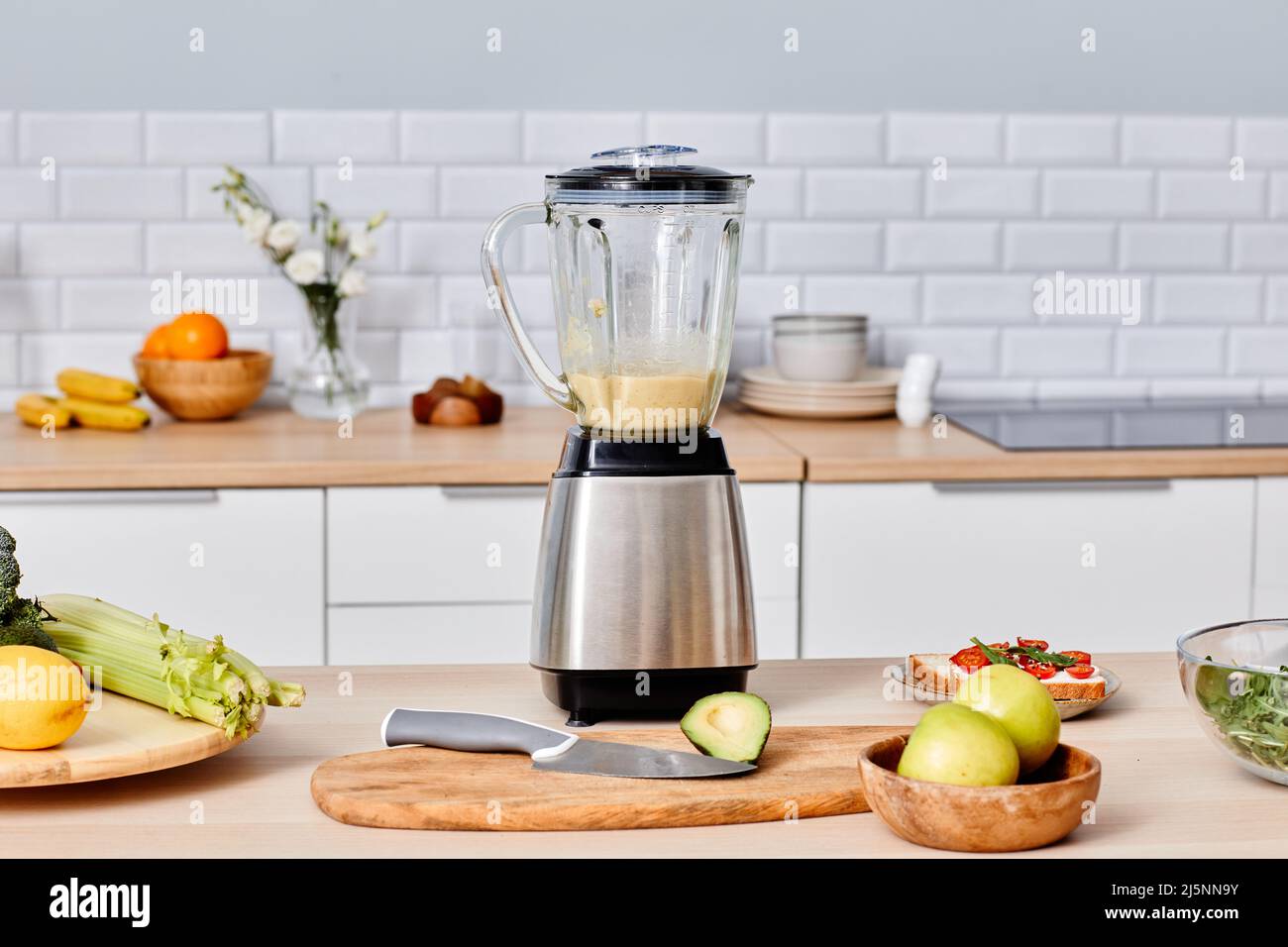 Modern electric blender with fresh cocktail inside standing on table ...