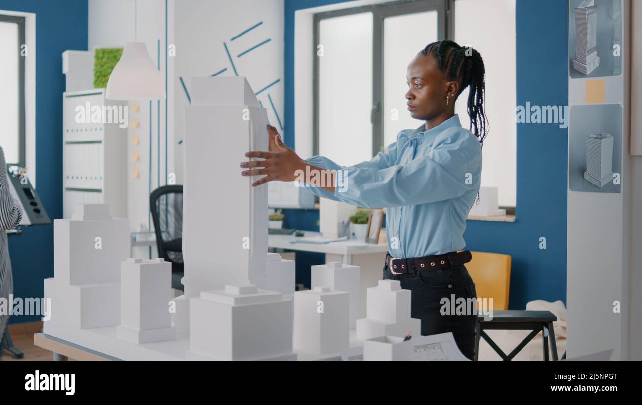 Woman Placing Blueprints Plan On Table To Design Building Model And Construction Layout