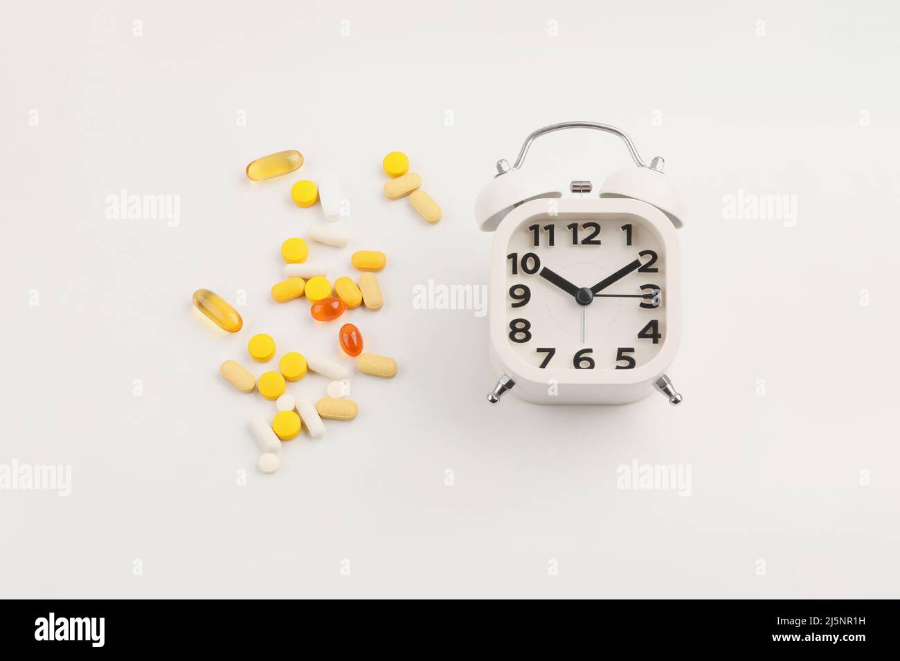 table clock, pills, white background, medical creative concept photo ...