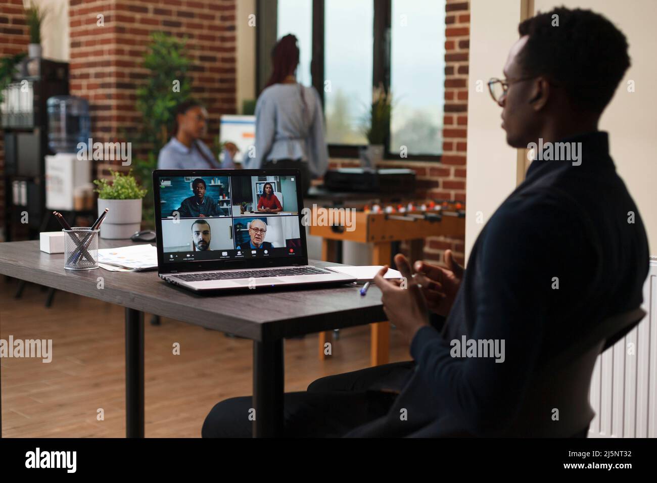 Marketing agency office worker talking with coworkers on digital video ...