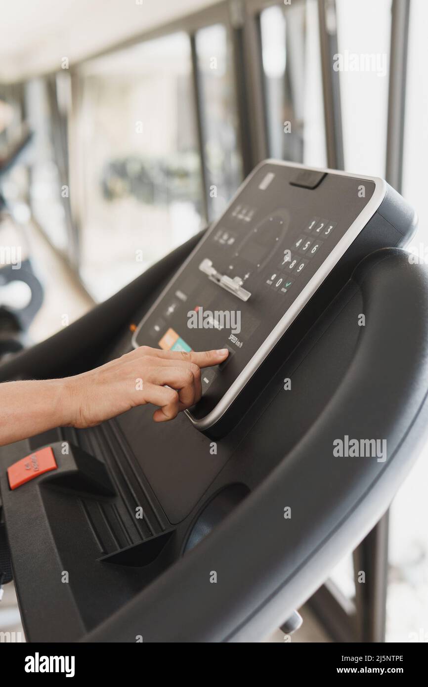 Woman changing settings on a treadmill in a gym Stock Photo - Alamy