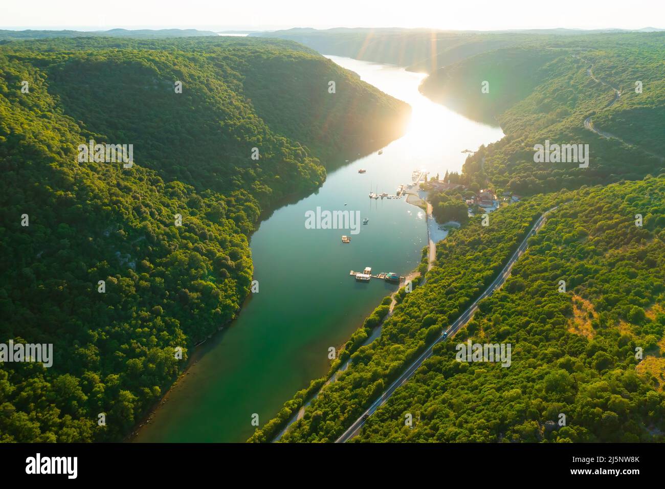 Sunset reflecting on water of Lim bay with high mountains surrounding ...