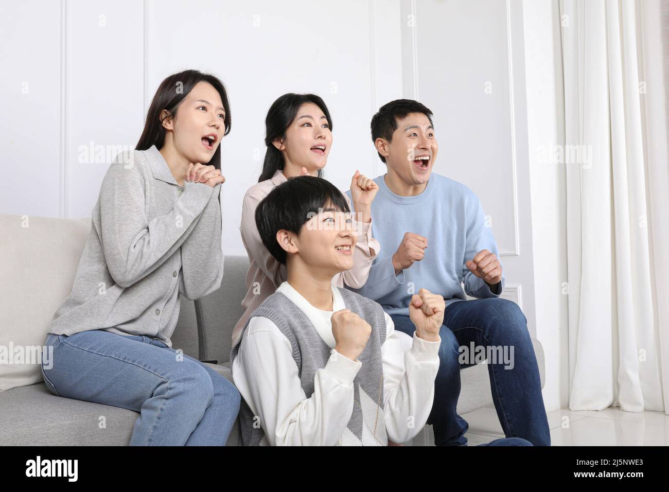 Asian Korean family Photo of a family cheering while watching TV Stock ...