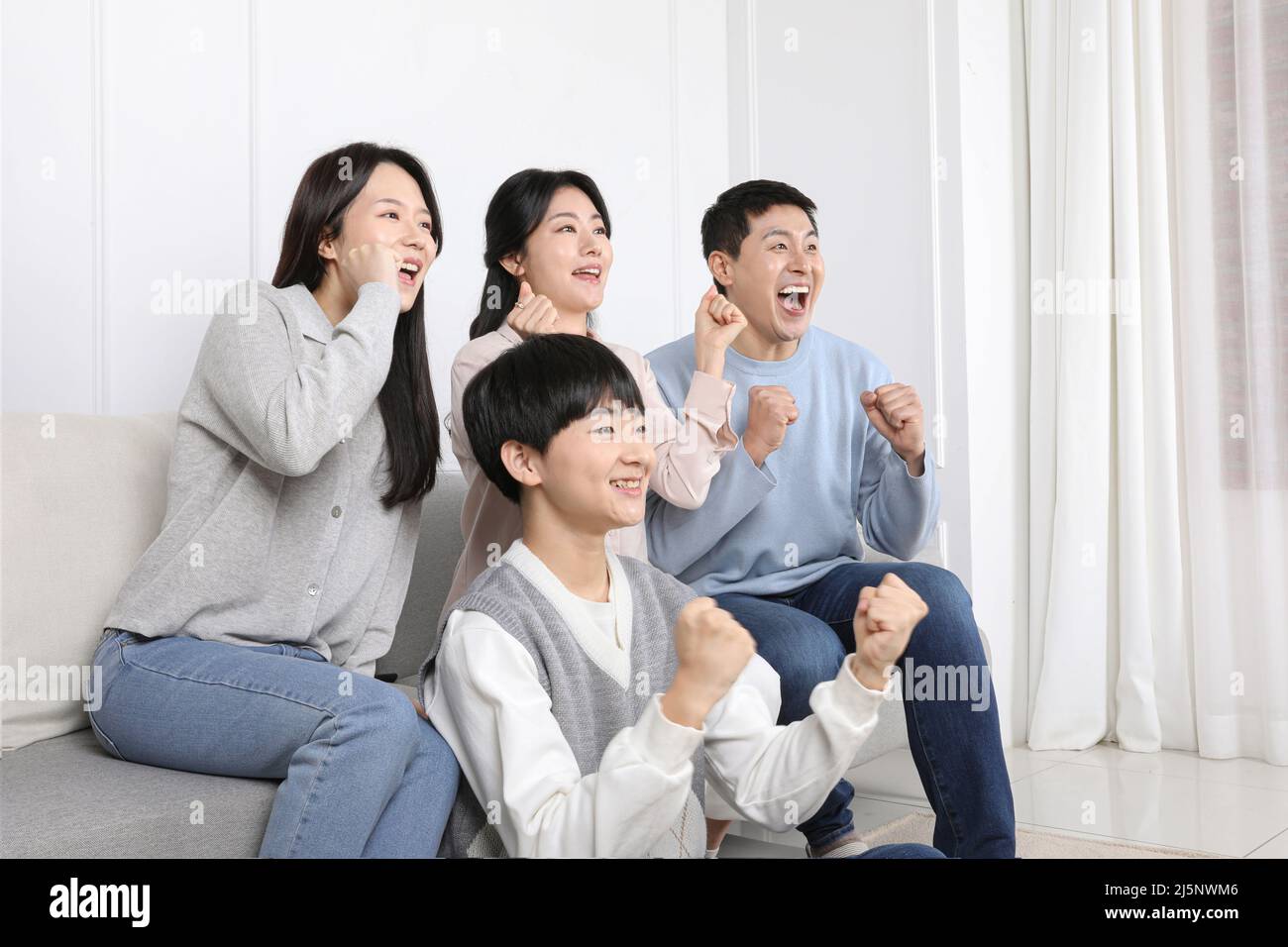 Asian Korean family Photo of a family cheering while watching TV Stock ...