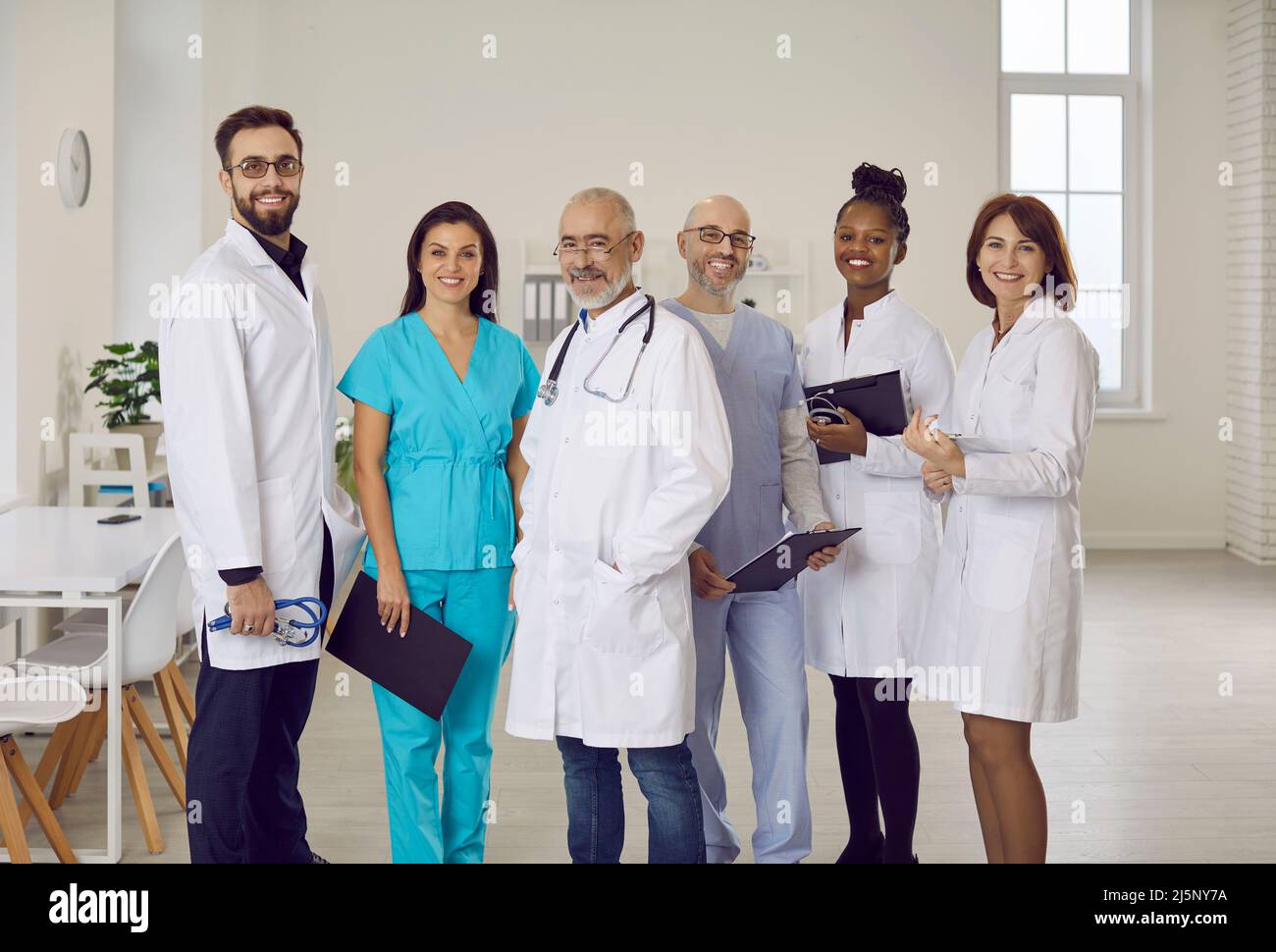 Diverse team of happy doctors who work at one hospital standing ...