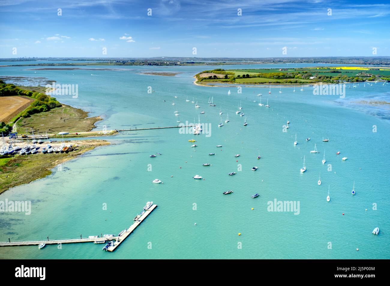 Rows of sailing boats anchored in a beautiful estuary in Chichester ...