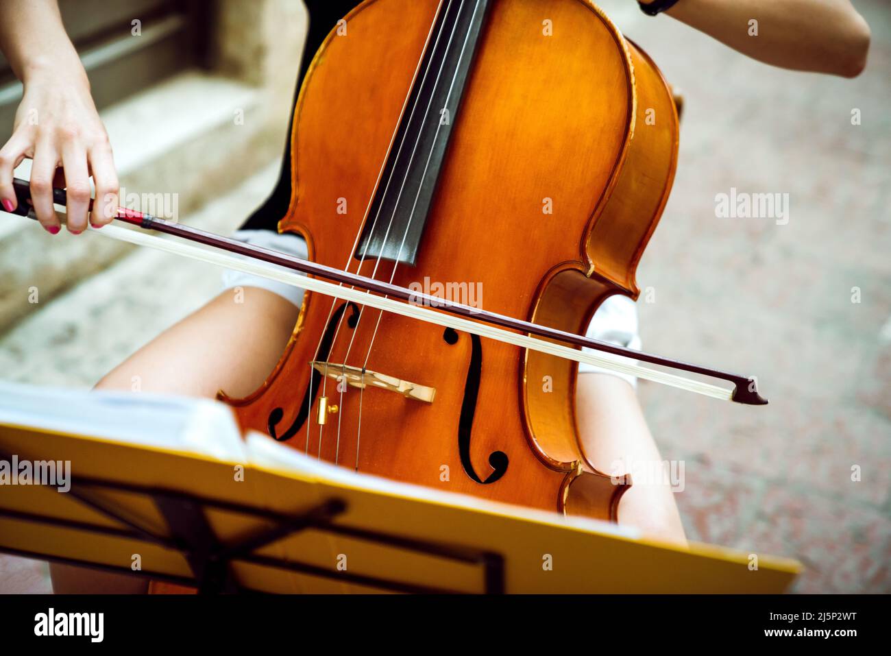 Happy young female musician playing the cello Stock Photo - Alamy