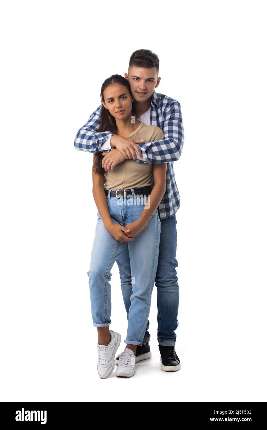 Full body portrait of young happy hugging couple, looking at camera ...