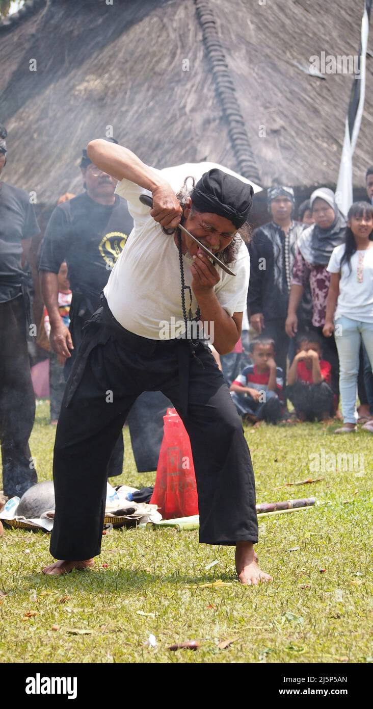 An old man showing off his immune skills by trying to cut his own ...
