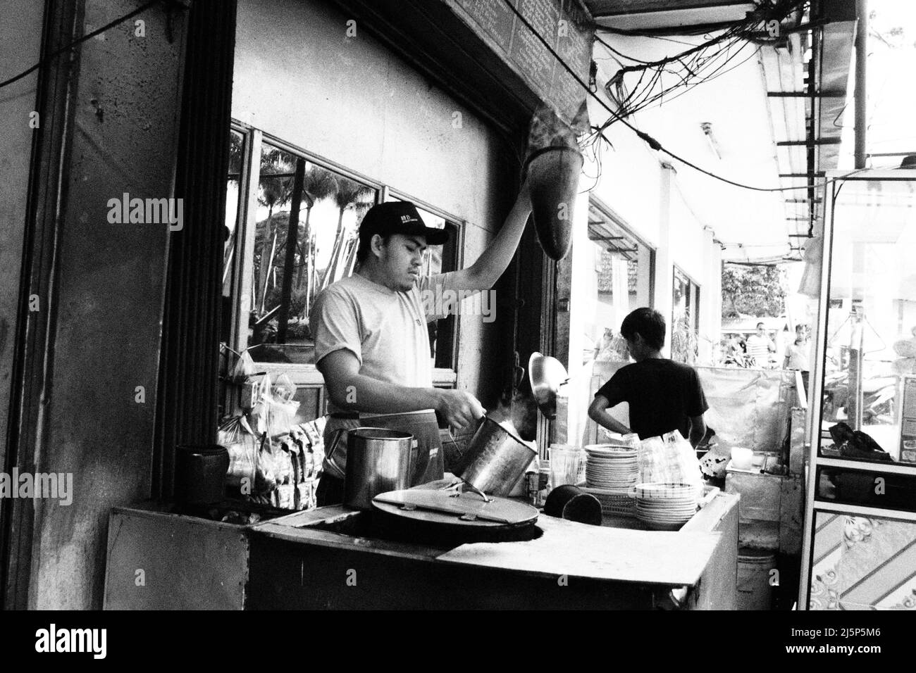 a coffee seller is making coffee the local way. In the local language ...