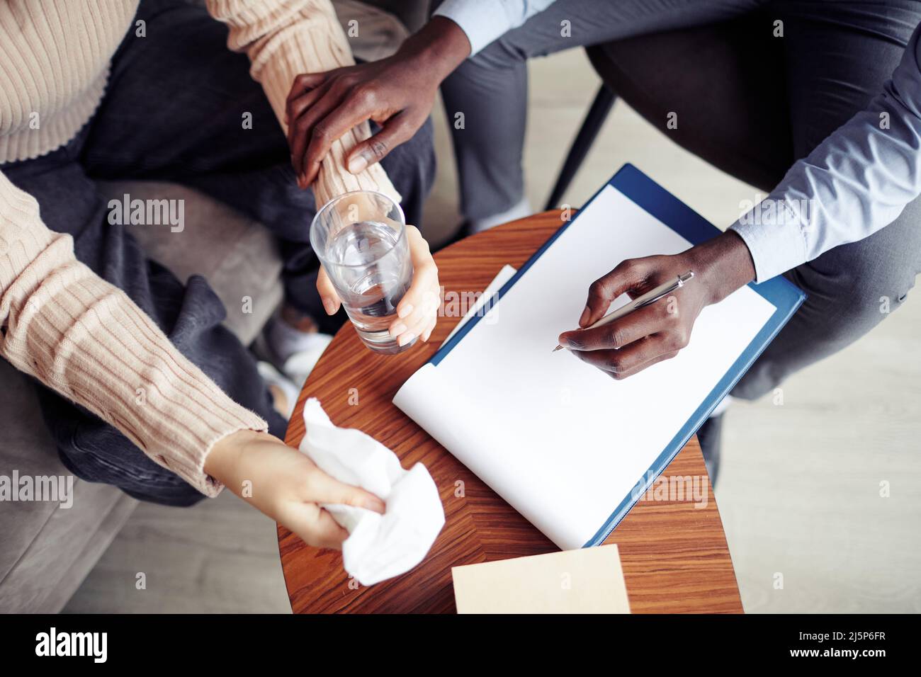 Close-up image of psychologist taking notes during therapy session with ...