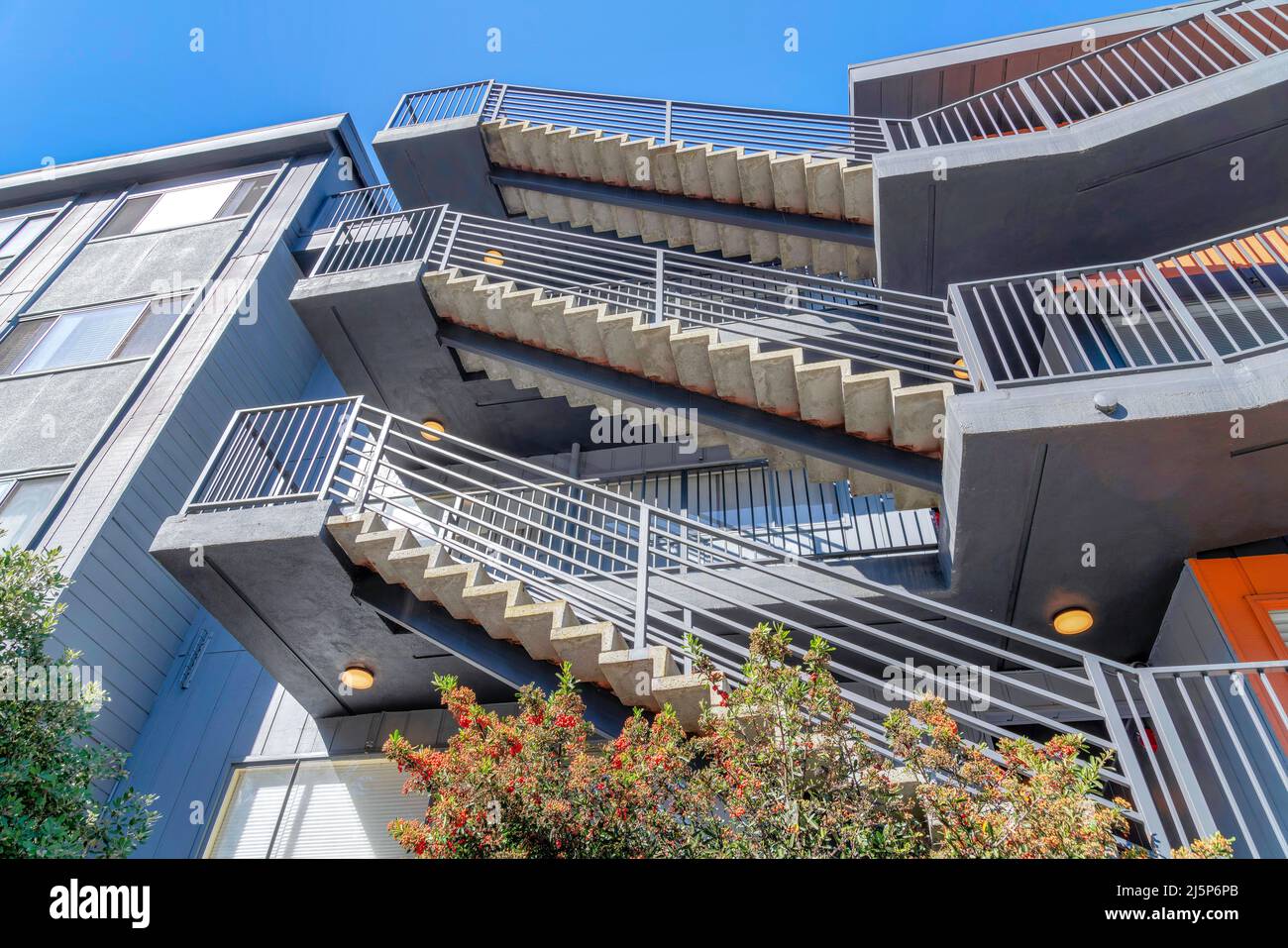 Low angle view of an apartment building with three outdoor straight ...