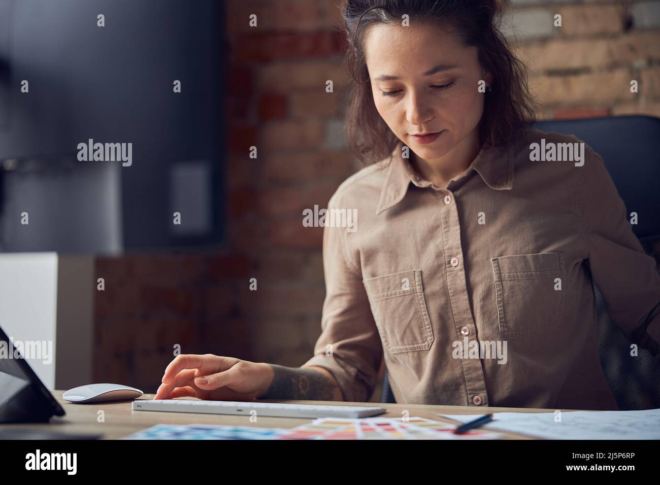 Female interior designer looking busy while working with drawing ...