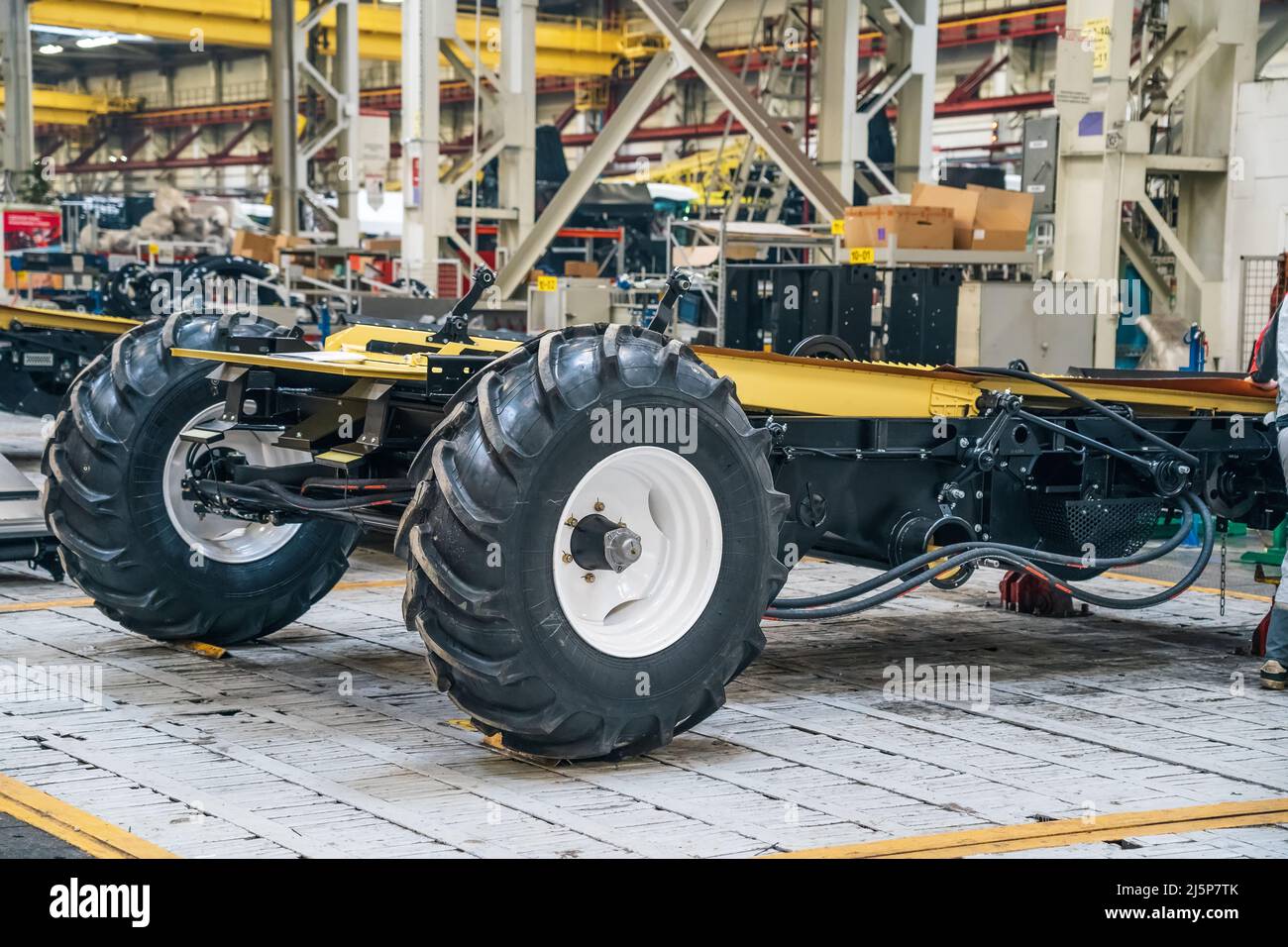 Agricultural combine in process of assembly on conveyor line in factory ...
