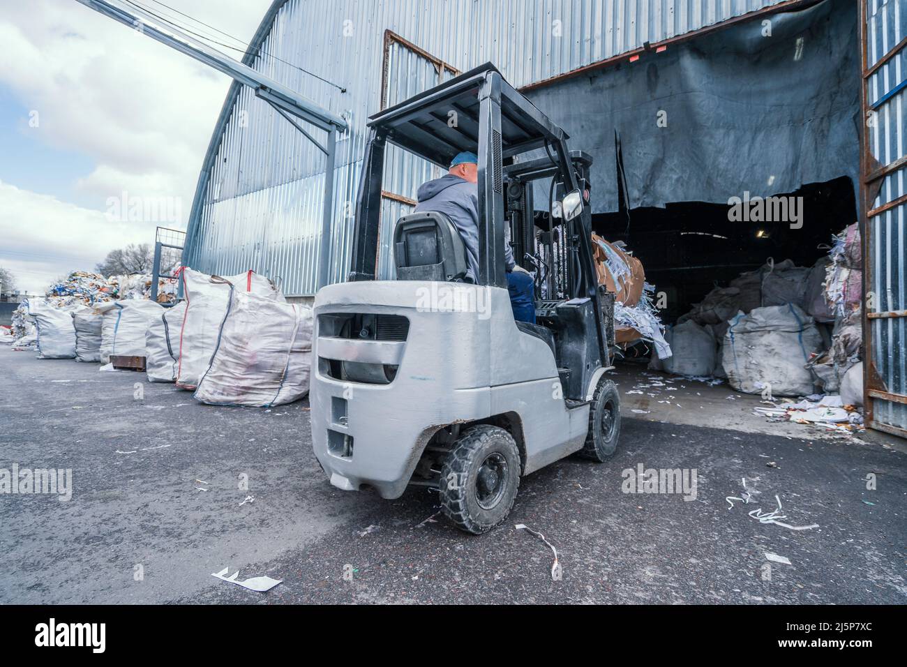 Forklift loading stack of paper and wastepaper into a paper recycling ...