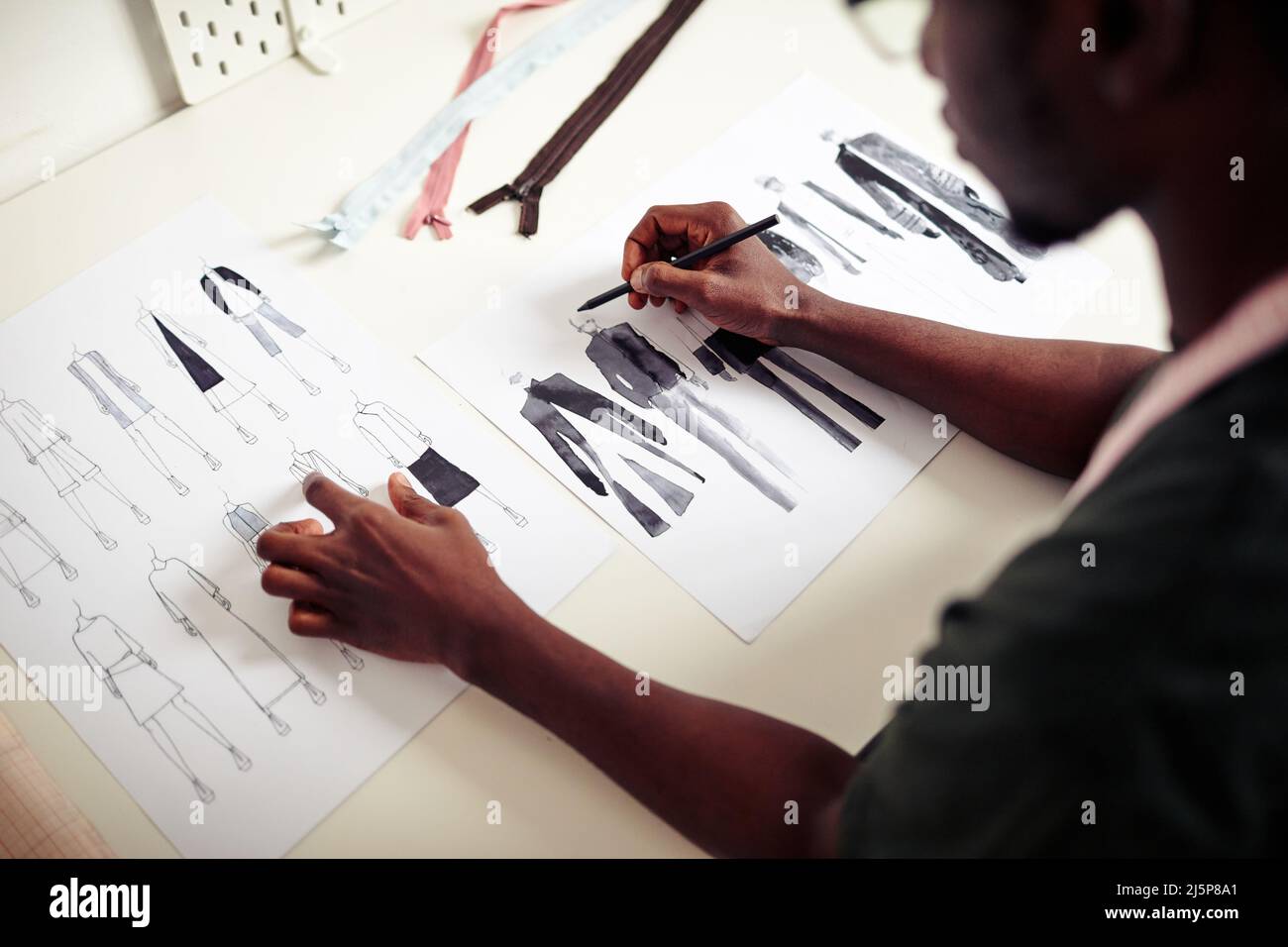 Talented young fashion design student drawing sketches of clothes for ...