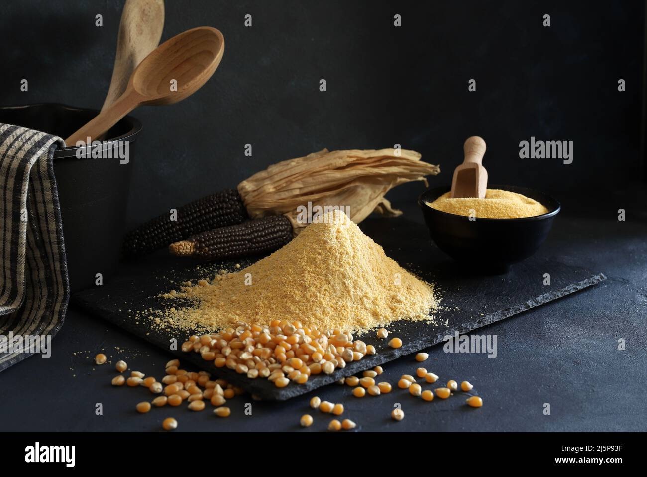 Cornmeal and corn kernels on a black background Stock Photo - Alamy