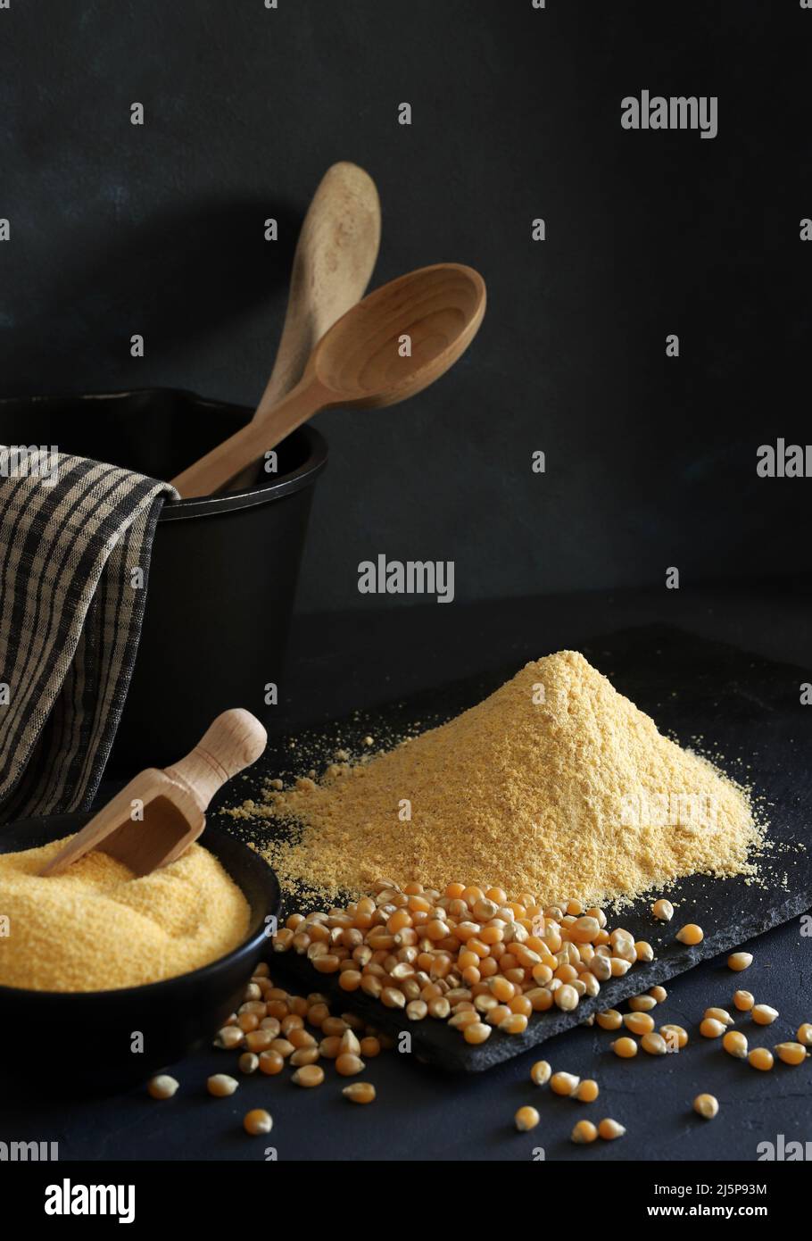 Cornmeal and corn kernels on a black background Stock Photo - Alamy