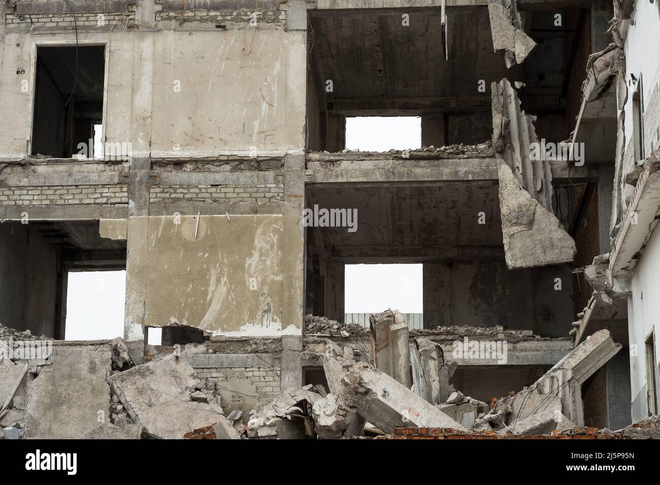 A destroyed building in close-up with a pile of concrete debris, slabs ...