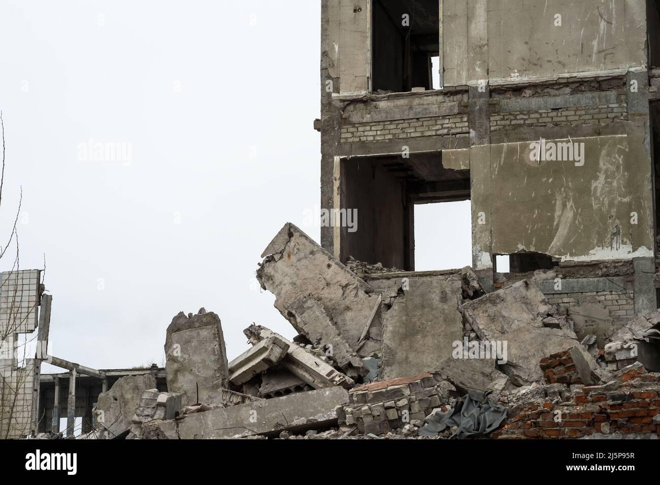 A ruined building in close-up against a gray sky with a pile of ...