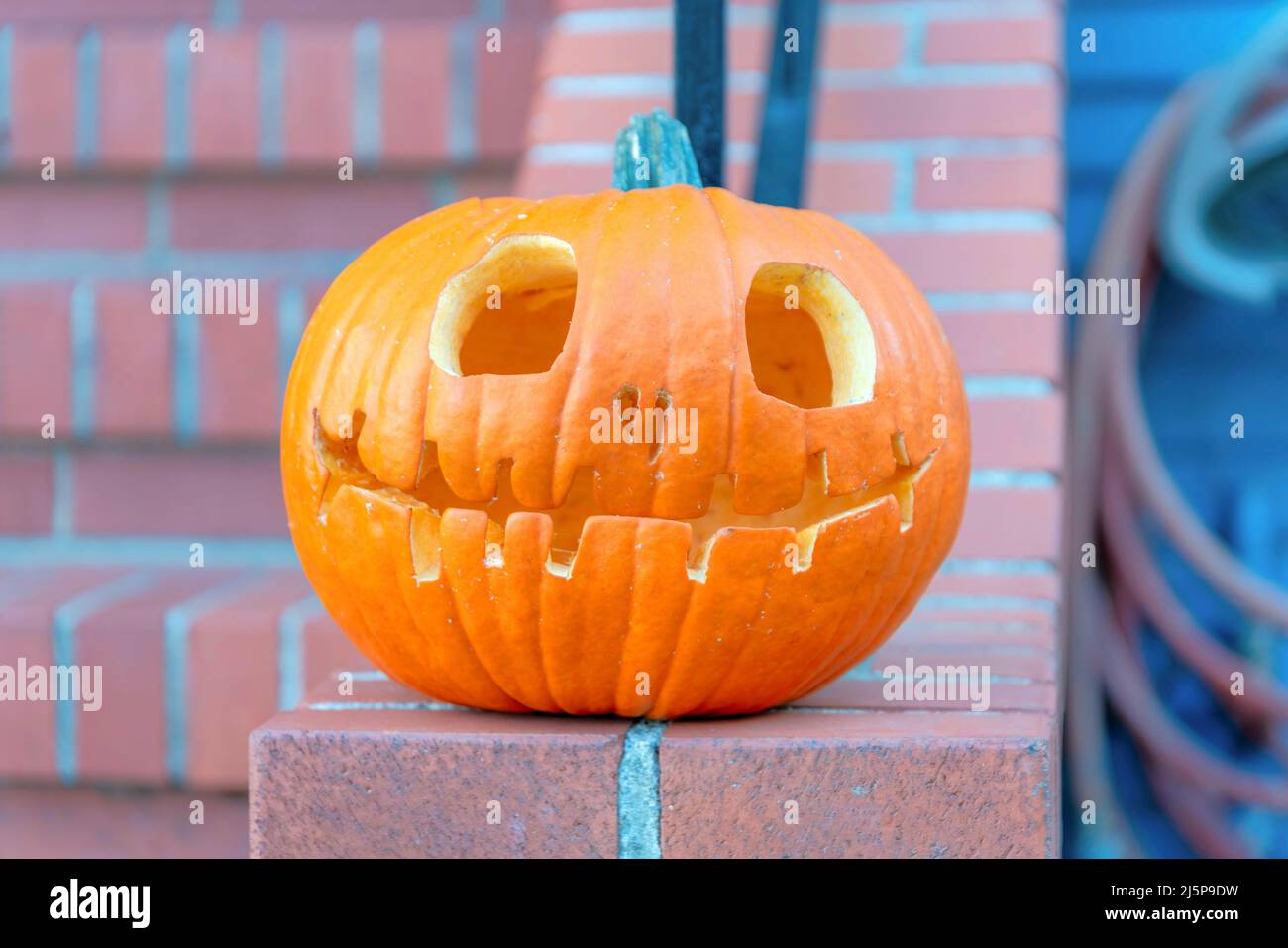 Carved pumpkin with eyes, nose, and mouth displayed outside the ...
