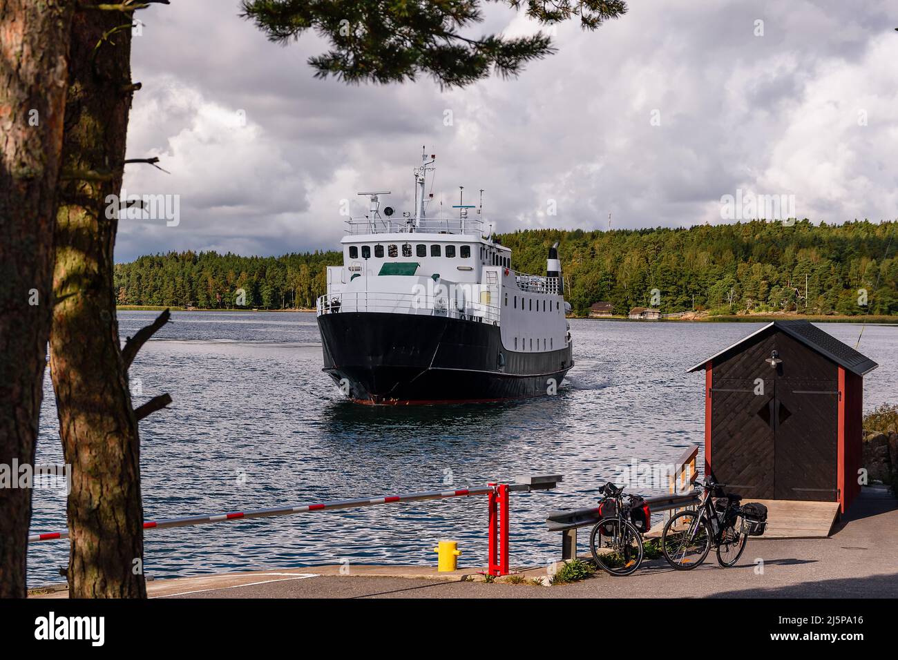 Small ferry carrying passengers and vehicles arriving in the harbor ...