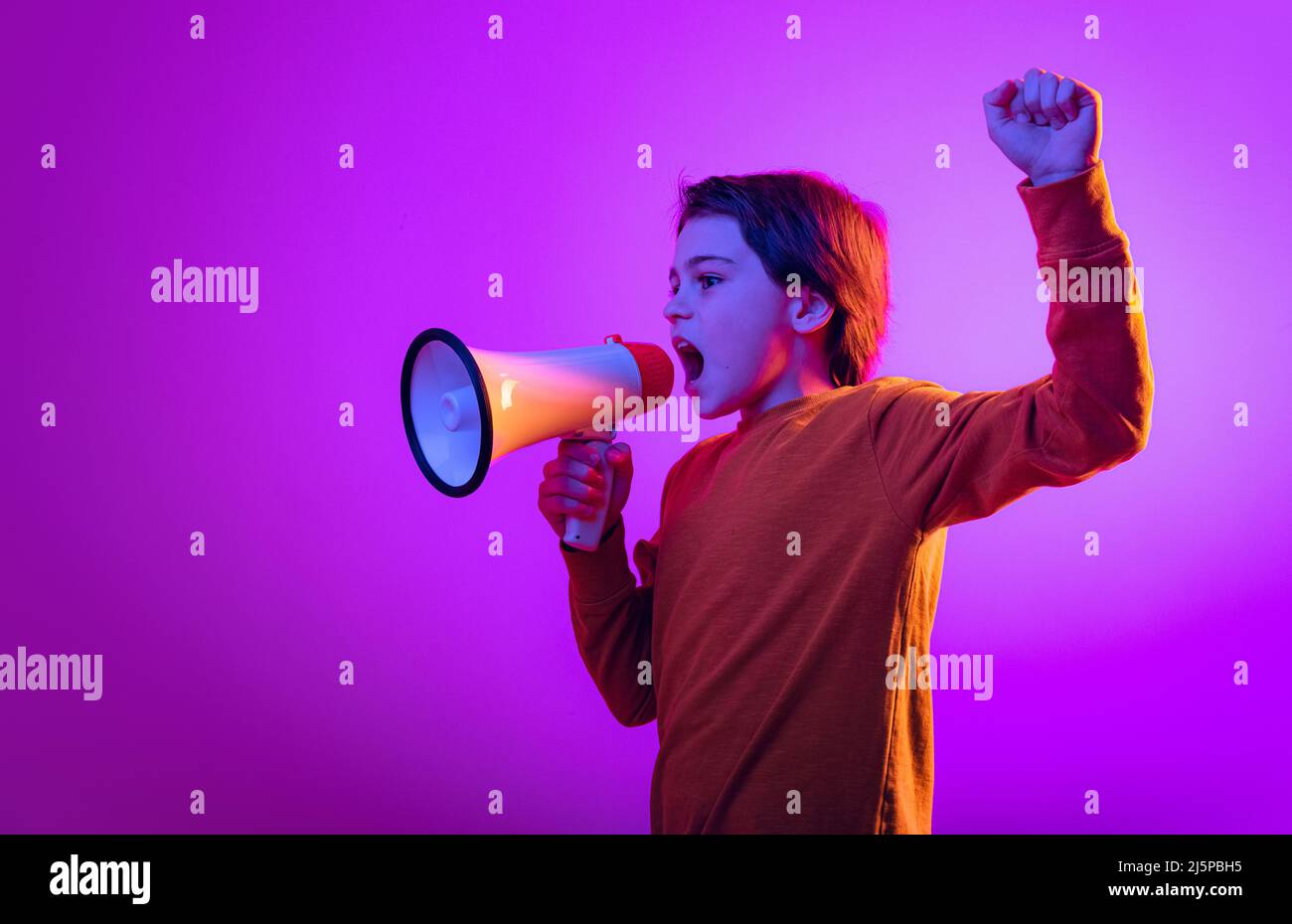 Portrait of boy, child shouting in megaphone, posing isolated over ...