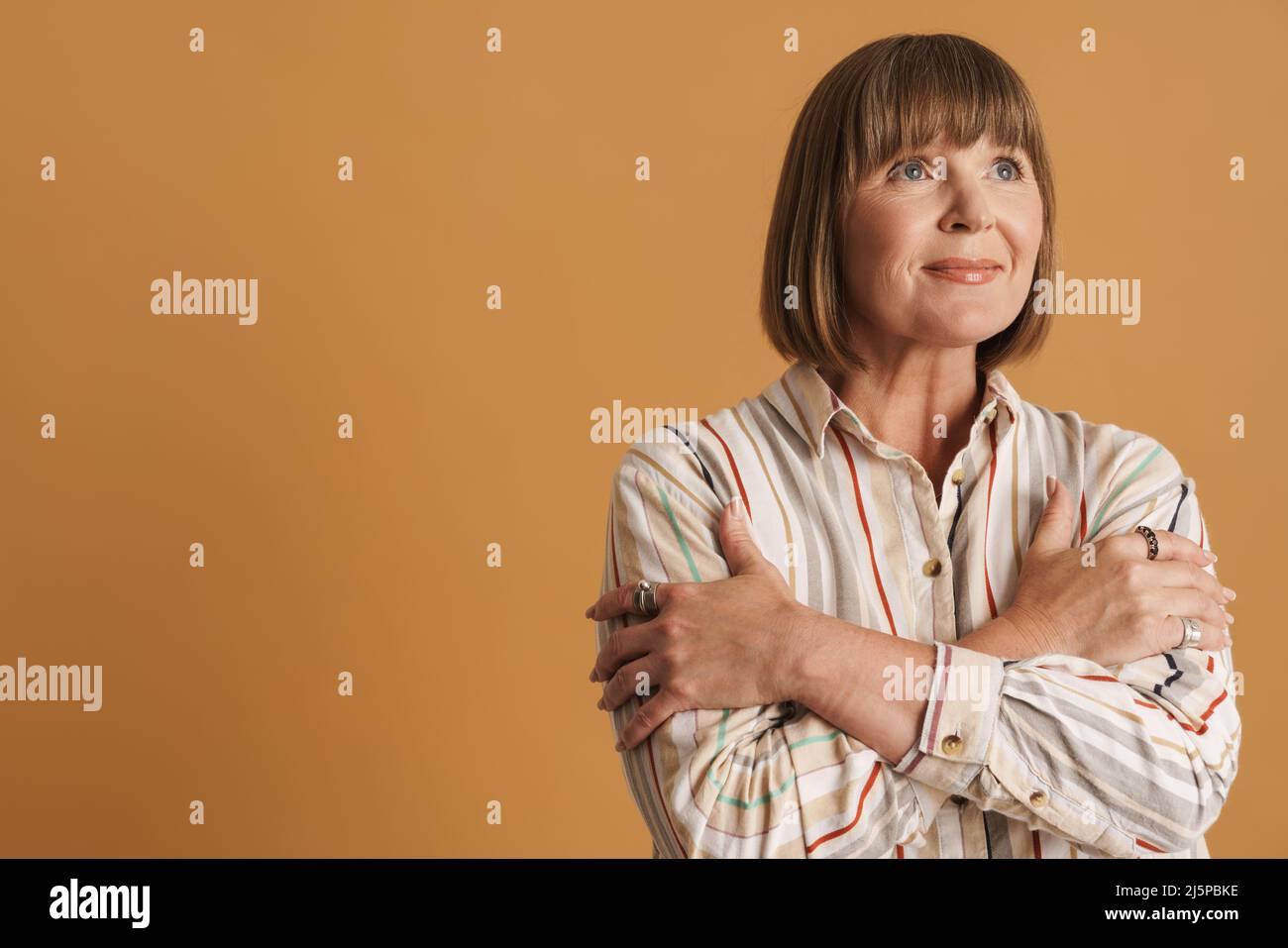 Senior woman wearing shirt posing with arms crossed on her chest ...