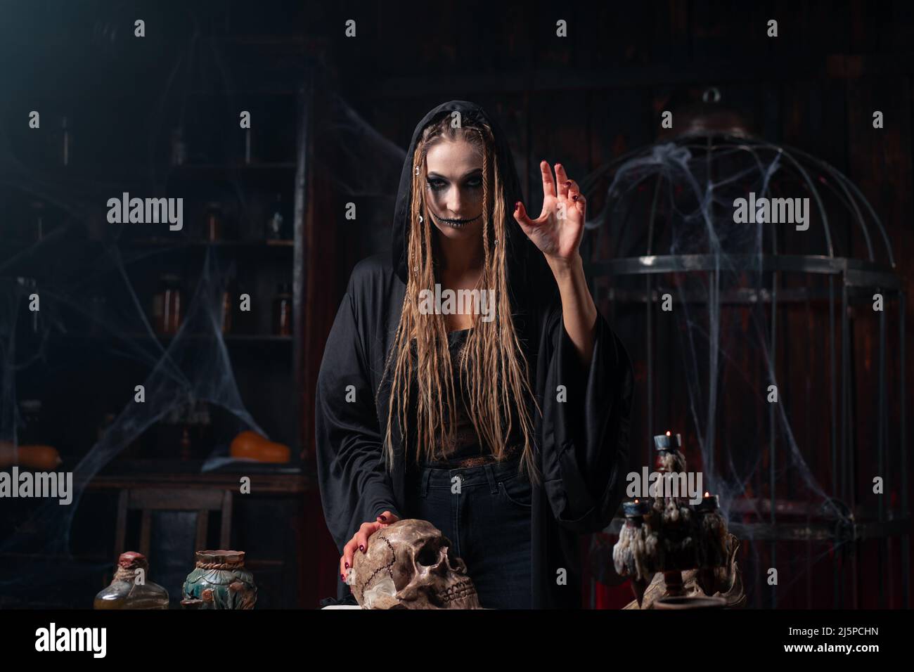 Halloween concept. Witch portrait close up with dreadlocks holding ...