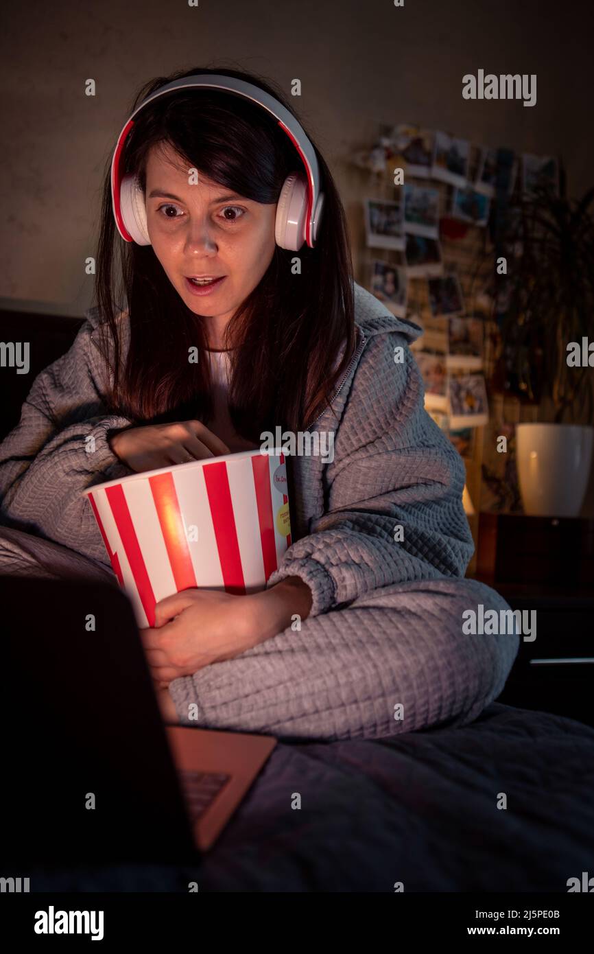 woman watching scary movie at home eating pop corn headset Stock Photo ...