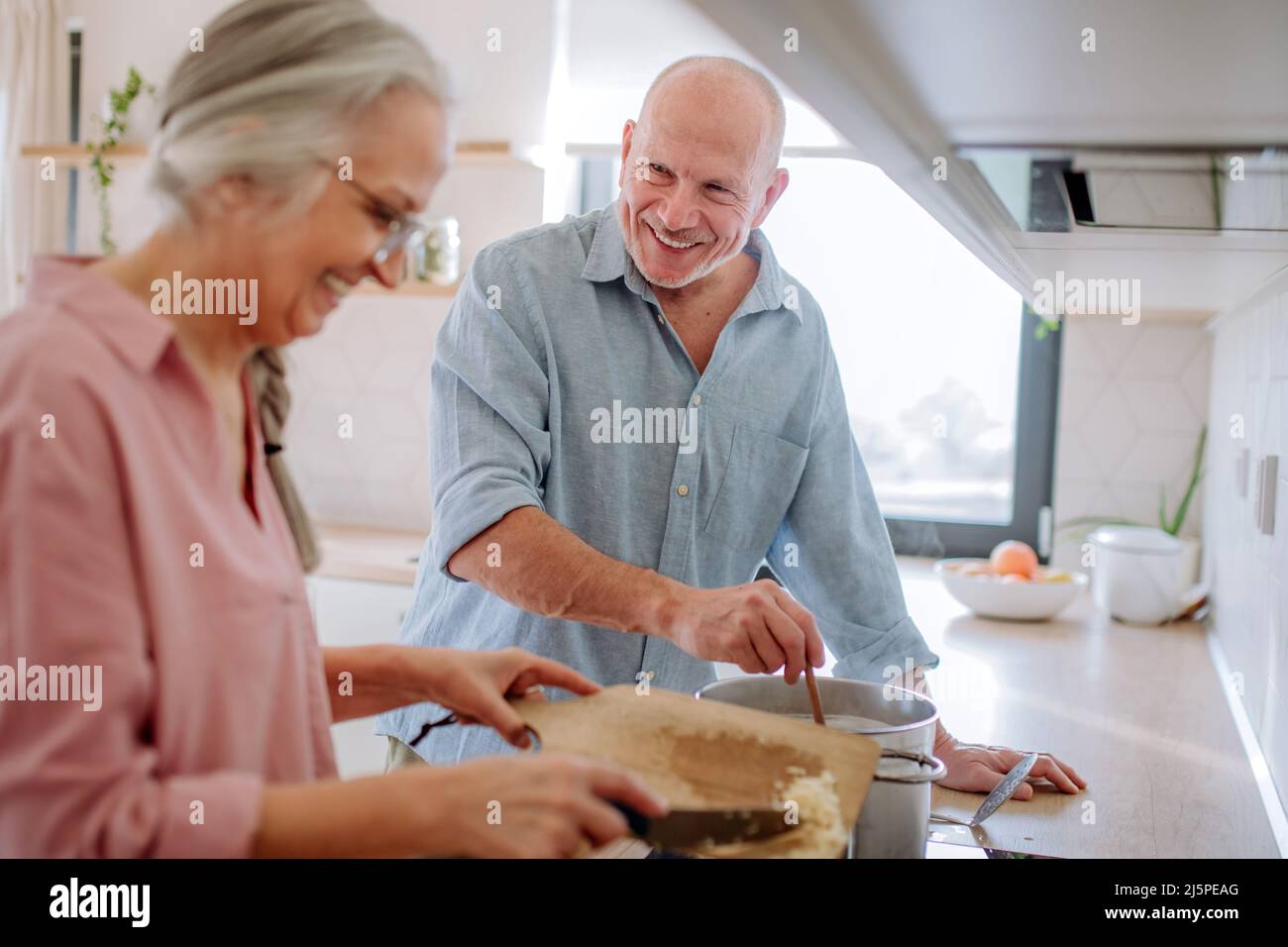 Happy senior couple cooking together at home Stock Photo - Alamy