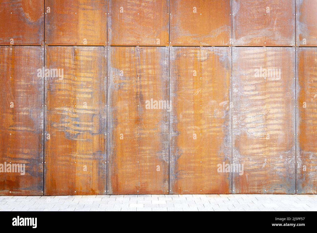 Modern architecture rusty metal wall and a sidewalk Stock Photo - Alamy