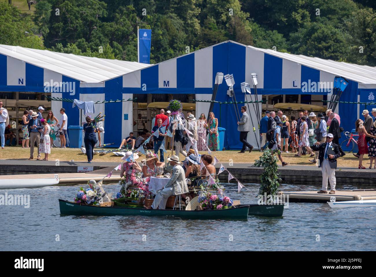Spectators on a picnic boat made from two canoes lashed together sails ...