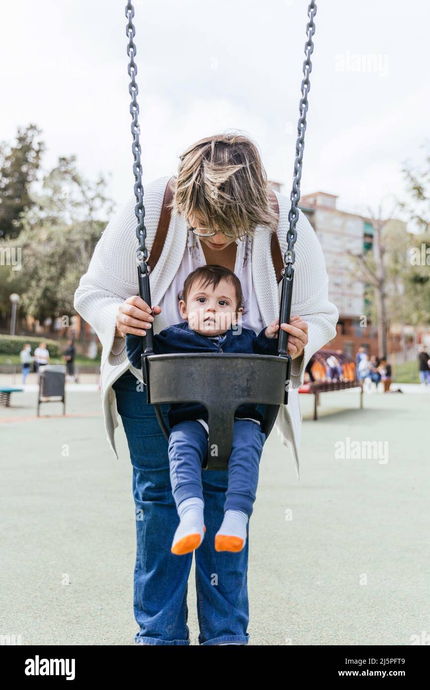 Child kid pushing swing hi-res stock photography and images - Alamy