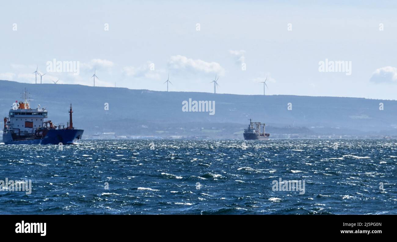 Cargo Ship Logistics and Green Energy Wind Turbines at the background ...