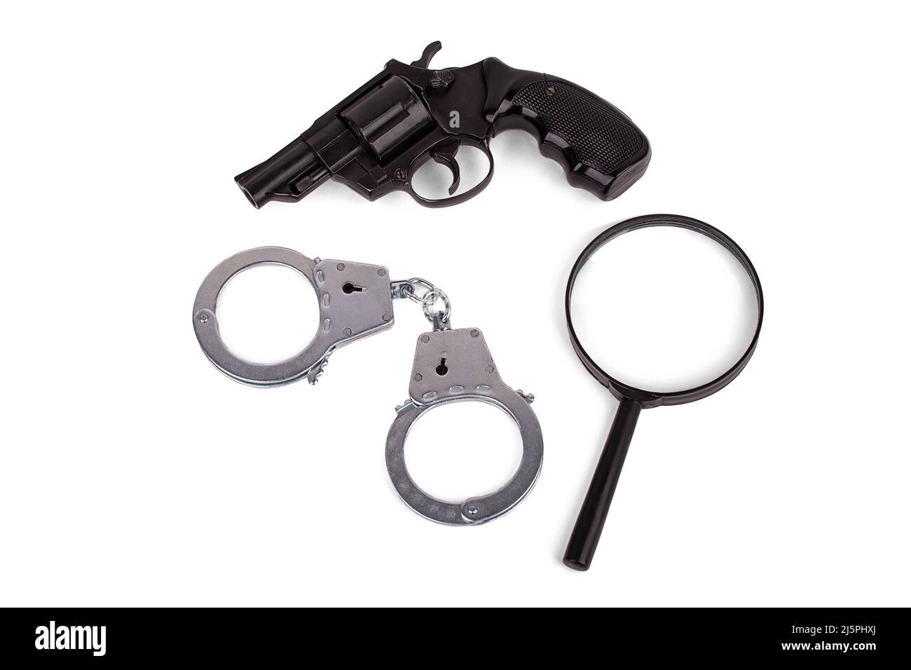 Handcuffs, pistol and magnifying glass, isolated on a white background ...