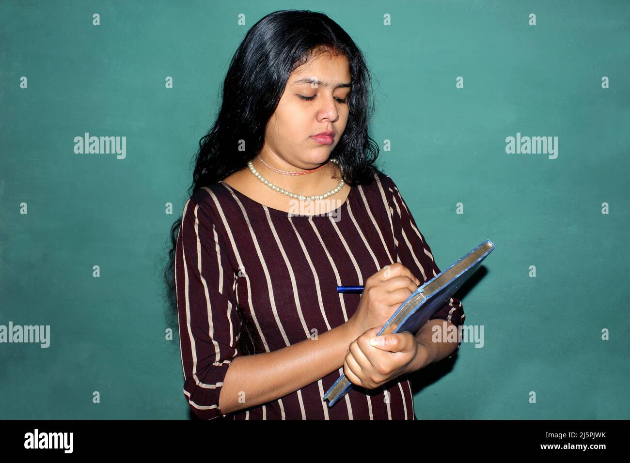 Pretty young girl posing with the book, girl writing, holding education ...