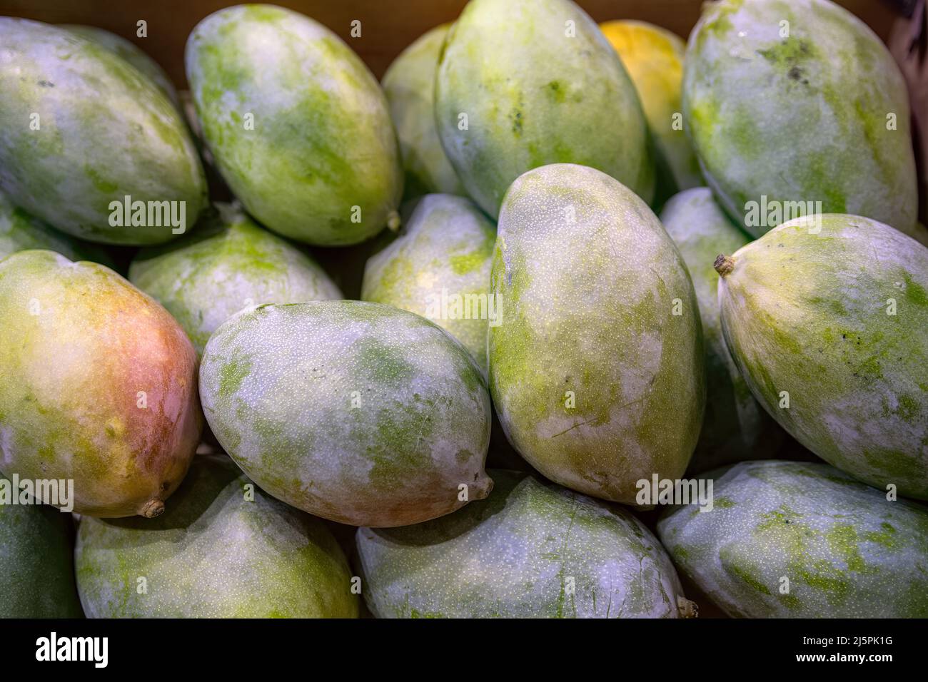 Mango fruit on the market stall. Group of fresh green mango for sell ...