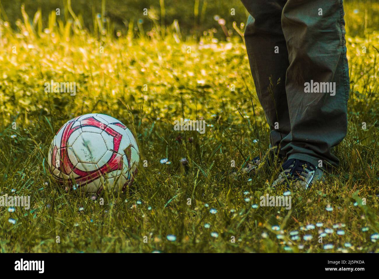 High angle view of men's legs and feet. Man ready to kick the ball with ...